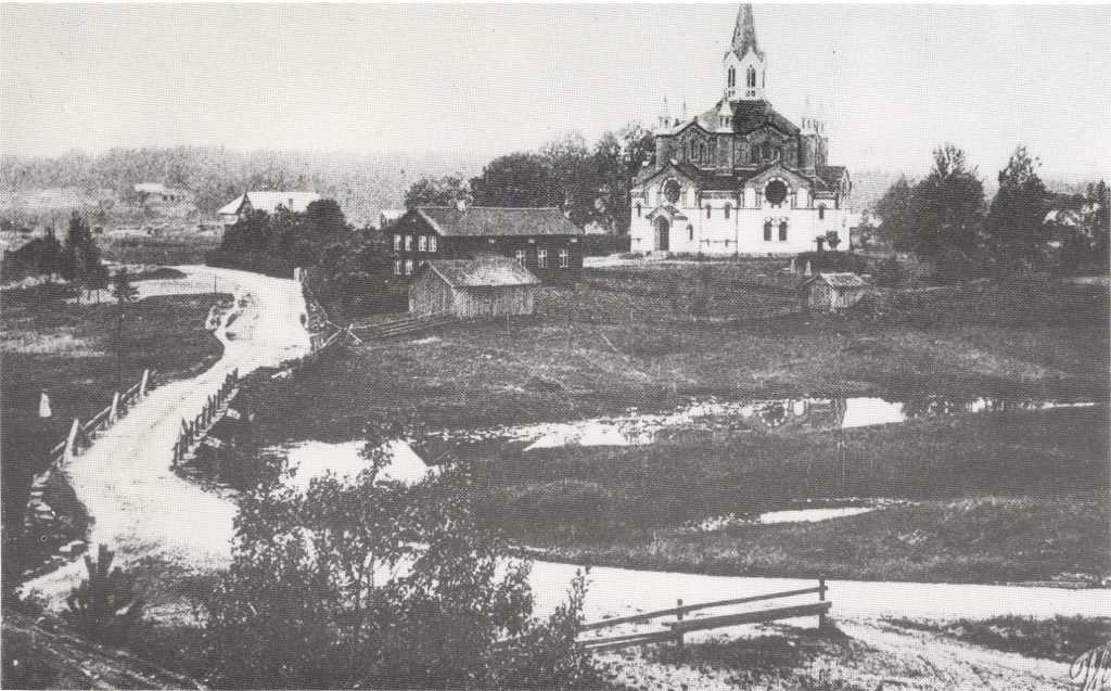 Tranemo kyrka. Till vänster den äldsta folkskolan byggd 1847. – Tranemo